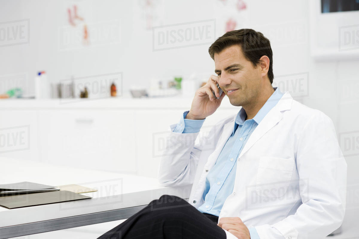 Doctor taking phone call in office - Stock Photo - Dissolve