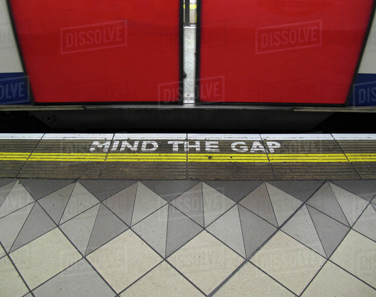 Mind the gap warning painted on the edge of the subway platform in the ...