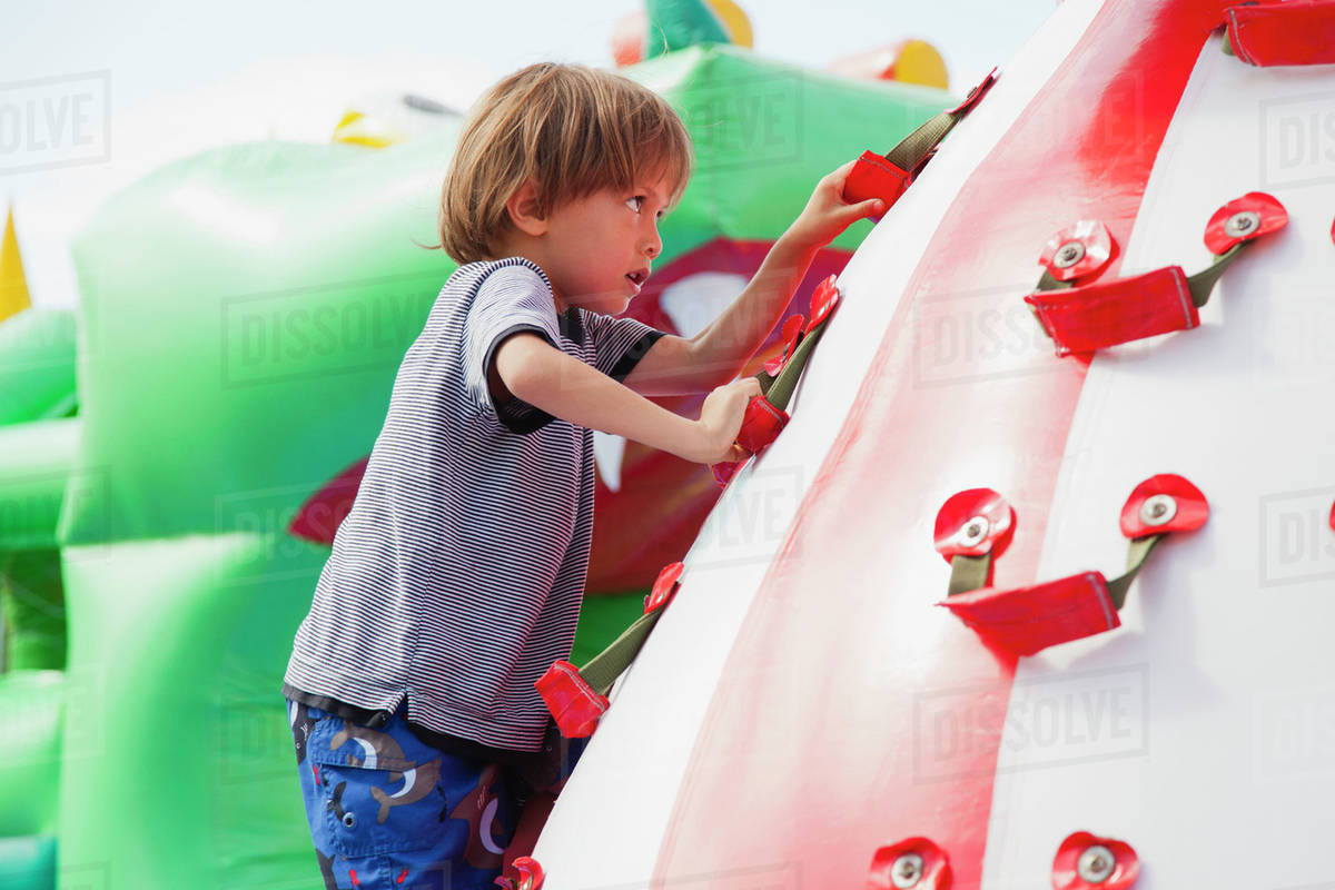 Boy climbing on playground - Stock Photo - Dissolve