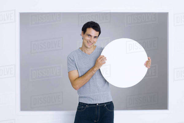 Man holding up round sign, smiling at camera - Royalty-free Stock Photo ...