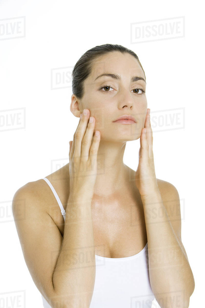 Woman touching cheeks with hands, looking at camera - Royalty-free ...