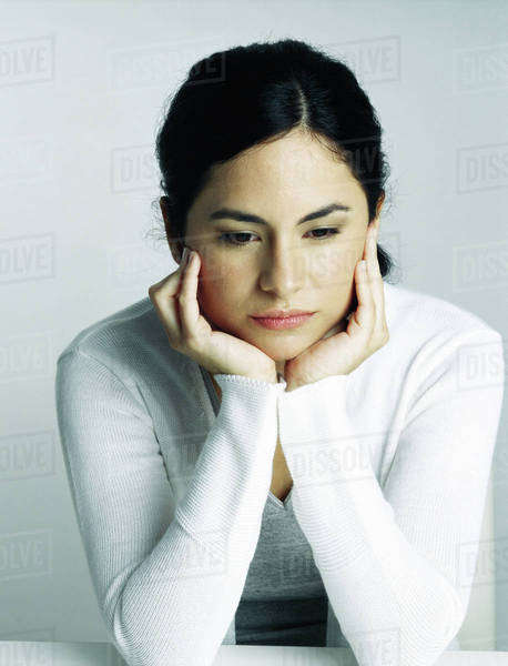 Young woman holding head in hands, looking down, portrait - Royalty ...