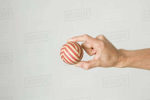 Hand holding striped ball - Royalty-free Stock Photo | Dissolve