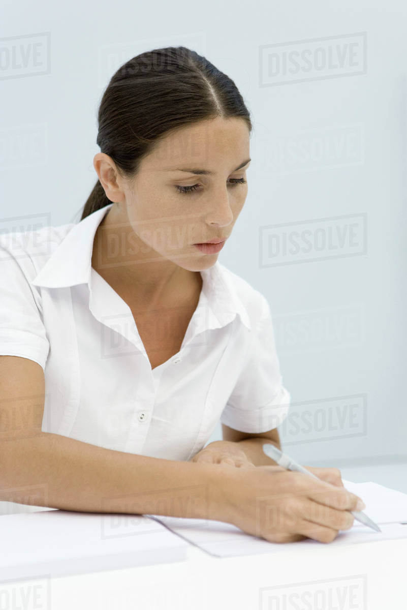 Woman reading document, holding pen - Royalty-free Stock Photo | Dissolve