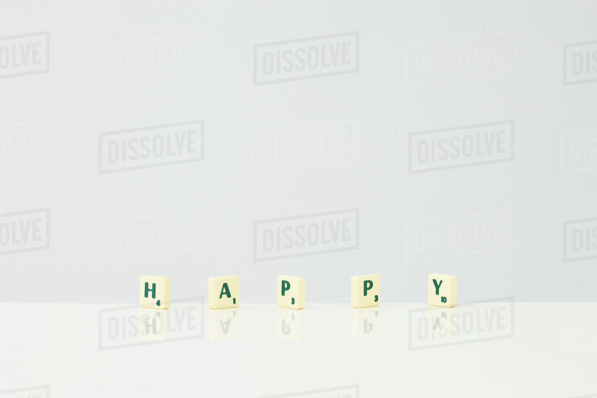 Word game tiles spelling the word "happy" - Stock Photo - Dissolve