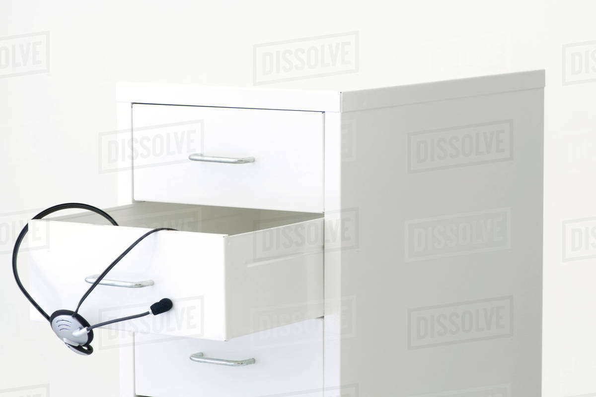 Headset hanging from an open drawer of a filing cabinet - Royalty-free ...