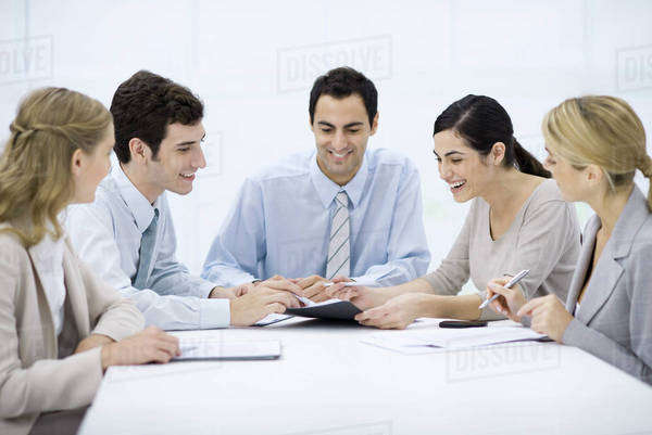 Group of professionals sitting at table, discussing document - Royalty ...