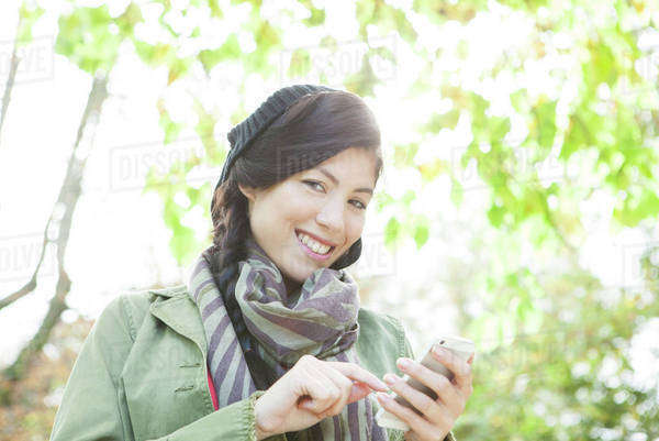Young woman using smartphone outdoors - Royalty-free Stock Photo | Dissolve