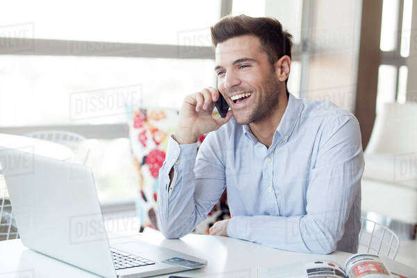 Man making cell phone call at home - Royalty-free Stock Photo | Dissolve