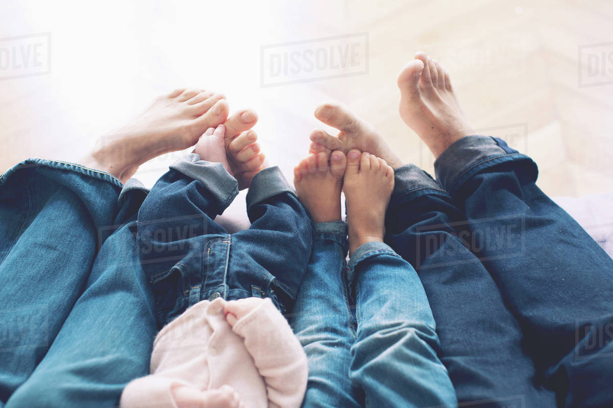 Outstretched legs and barefeet of family with two children - Stock ...