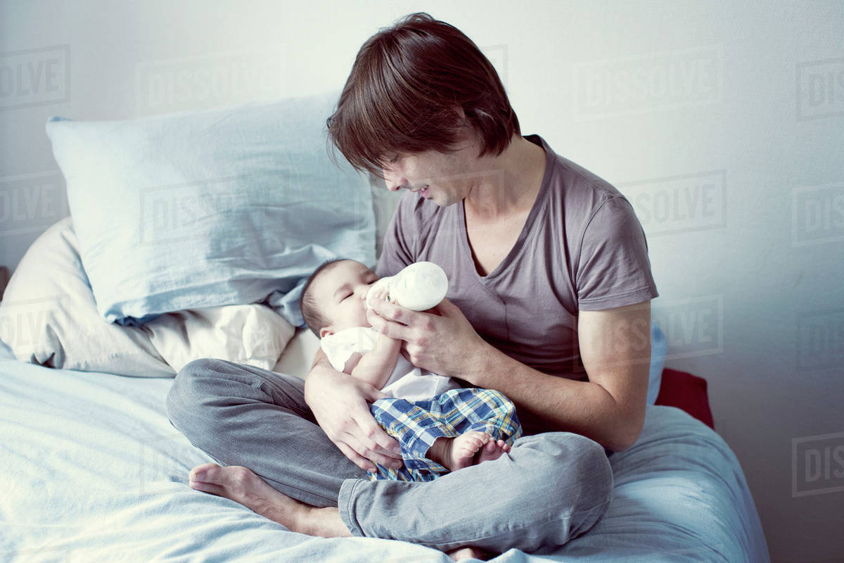 Father feeding bottle feeding baby - Stock Photo - Dissolve