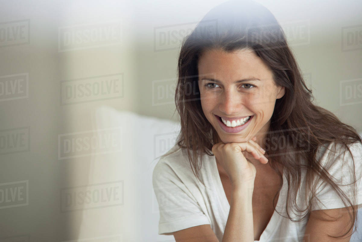 Woman resting head on chin, smiling - Royalty-free Stock Photo | Dissolve