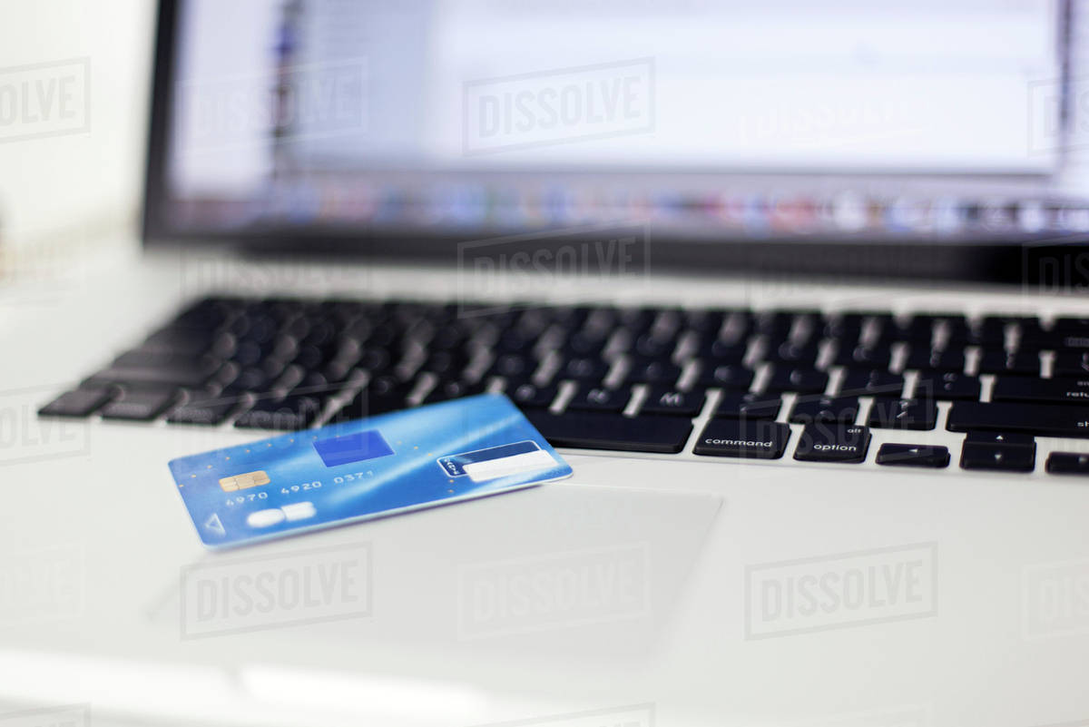 Credit card resting on laptop computer - Stock Photo - Dissolve