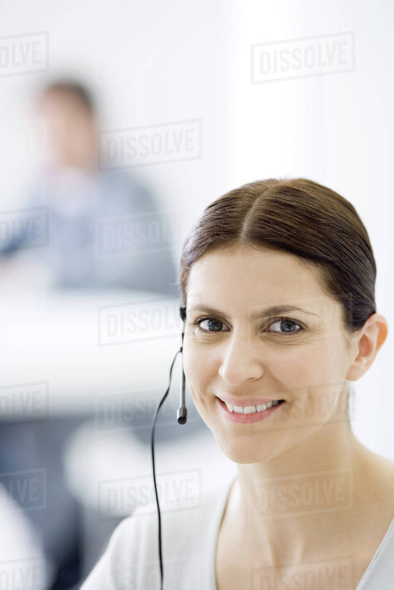 Woman wearing headset, smiling at camera, portrait - Royalty-free Stock ...