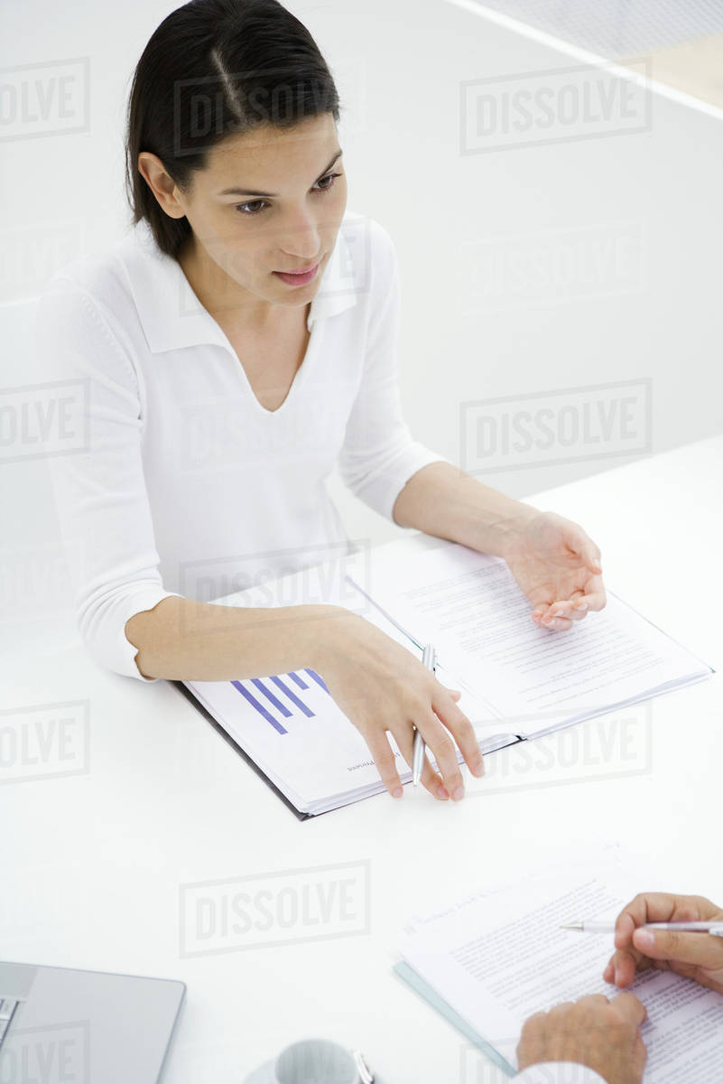 Professional woman discussing documents with colleague, cropped view ...