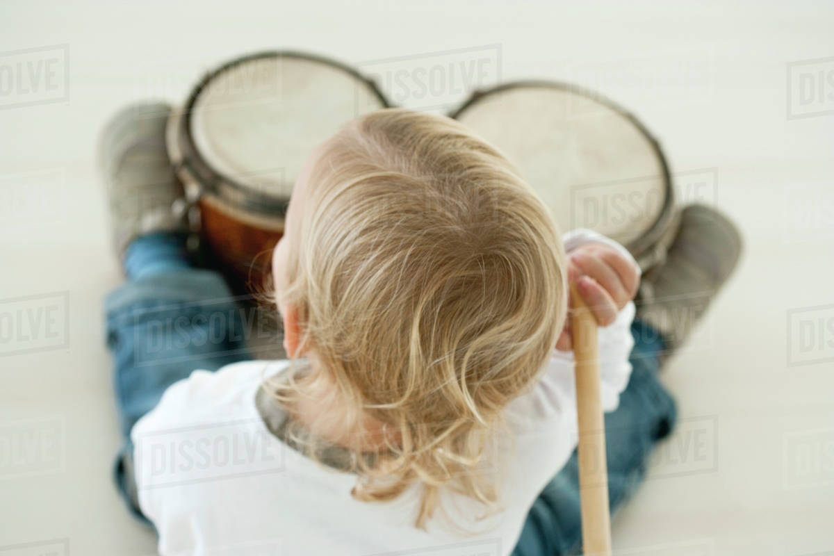 Baby boy playing drums, rear view - Royalty-free Stock Photo | Dissolve