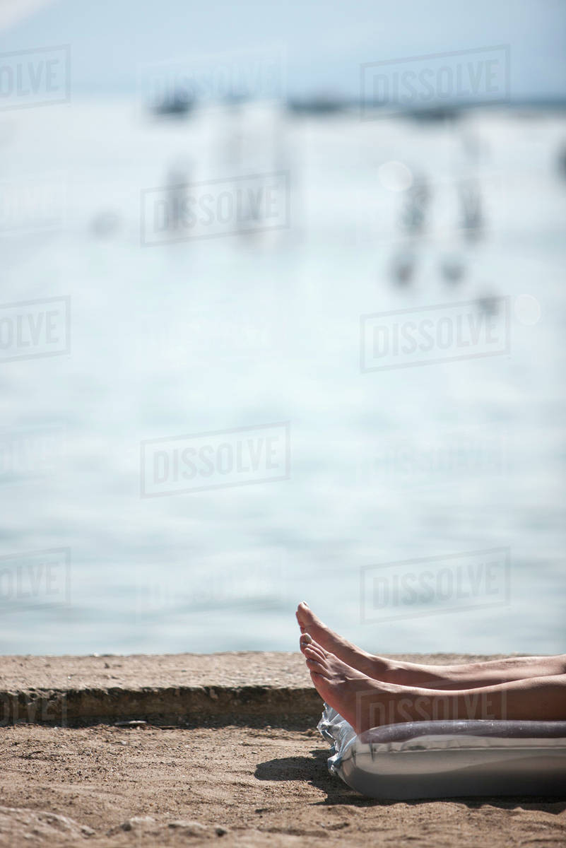Person lying by water, low section - Royalty-free Stock Photo | Dissolve