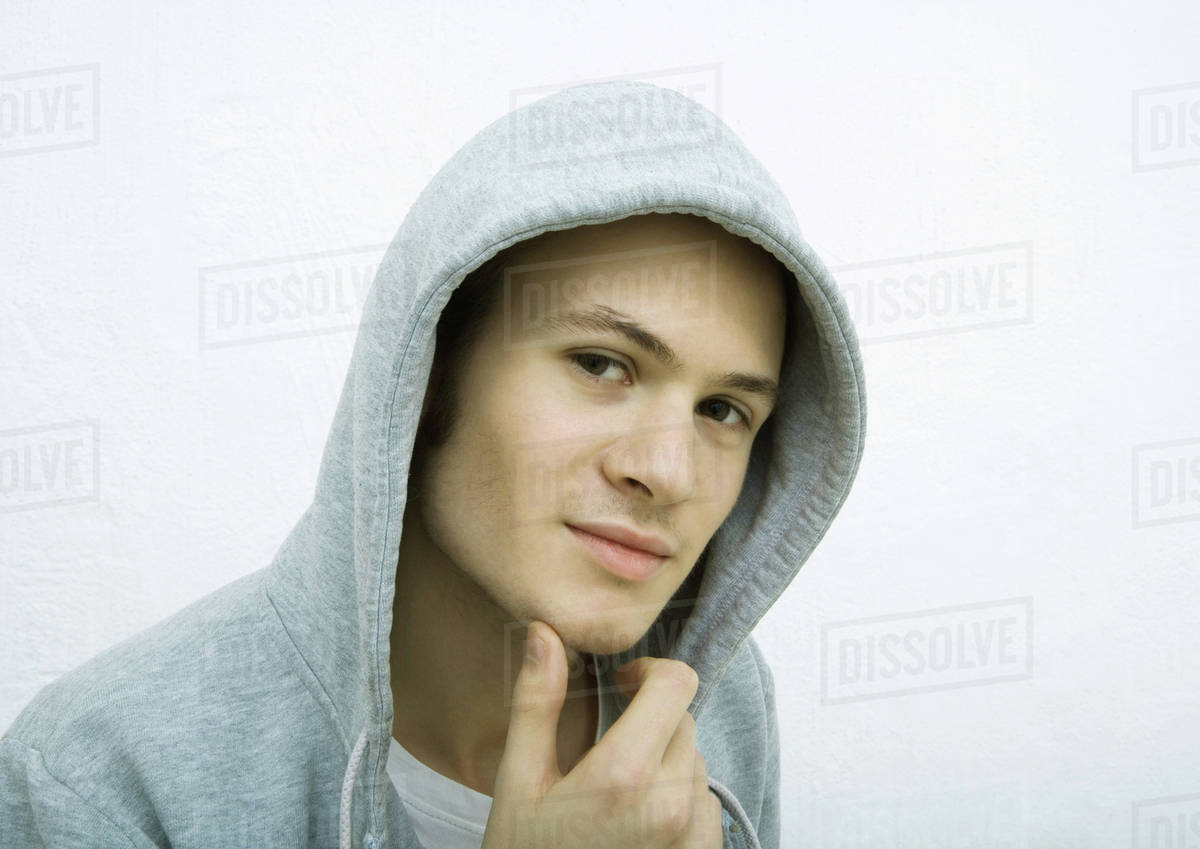 Young man scratching chin, wearing hood, portrait - Royalty-free Stock ...