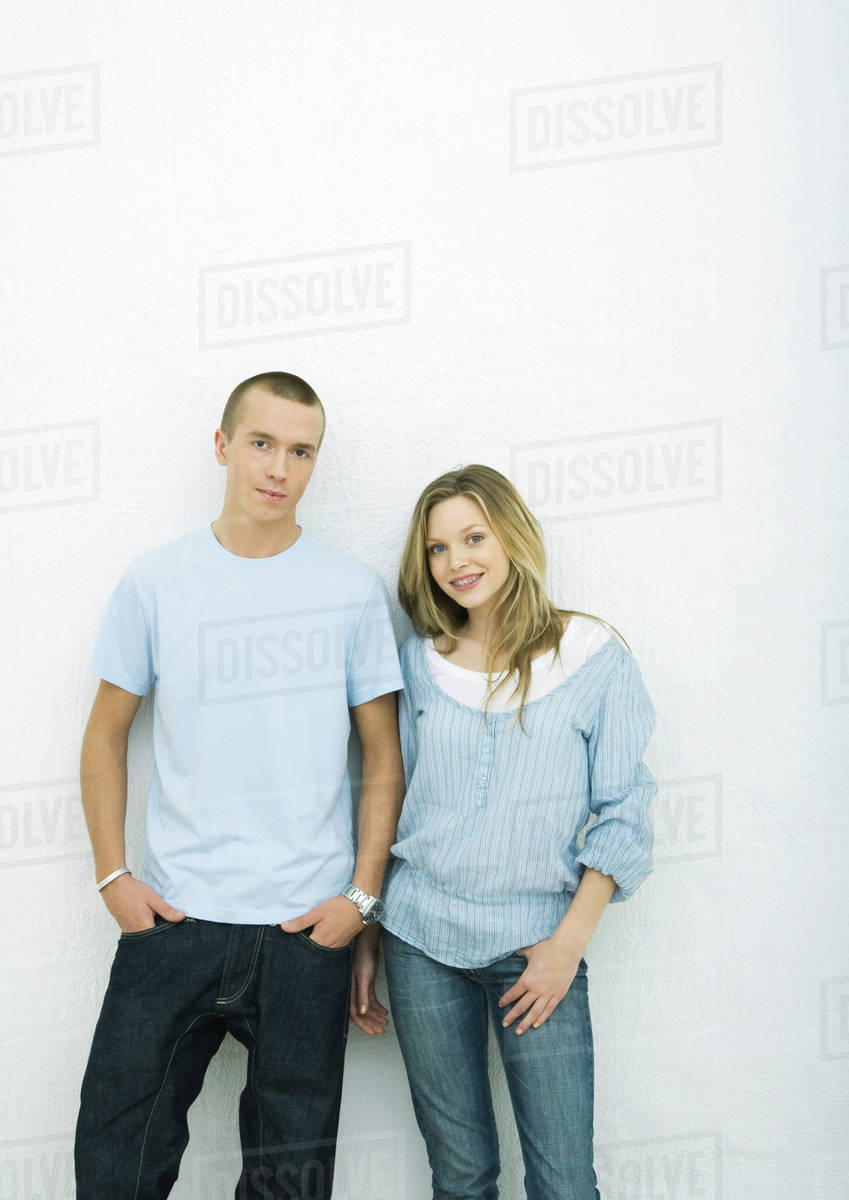 Young couple standing side by side, looking at camera, portrait, white ...