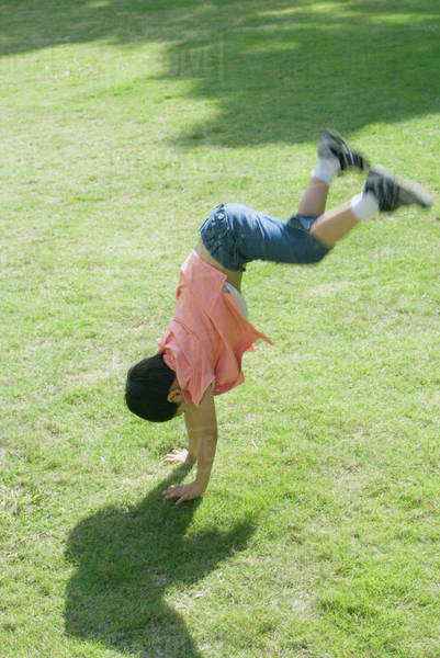 Boy doing handstand on grass - Royalty-free Stock Photo | Dissolve