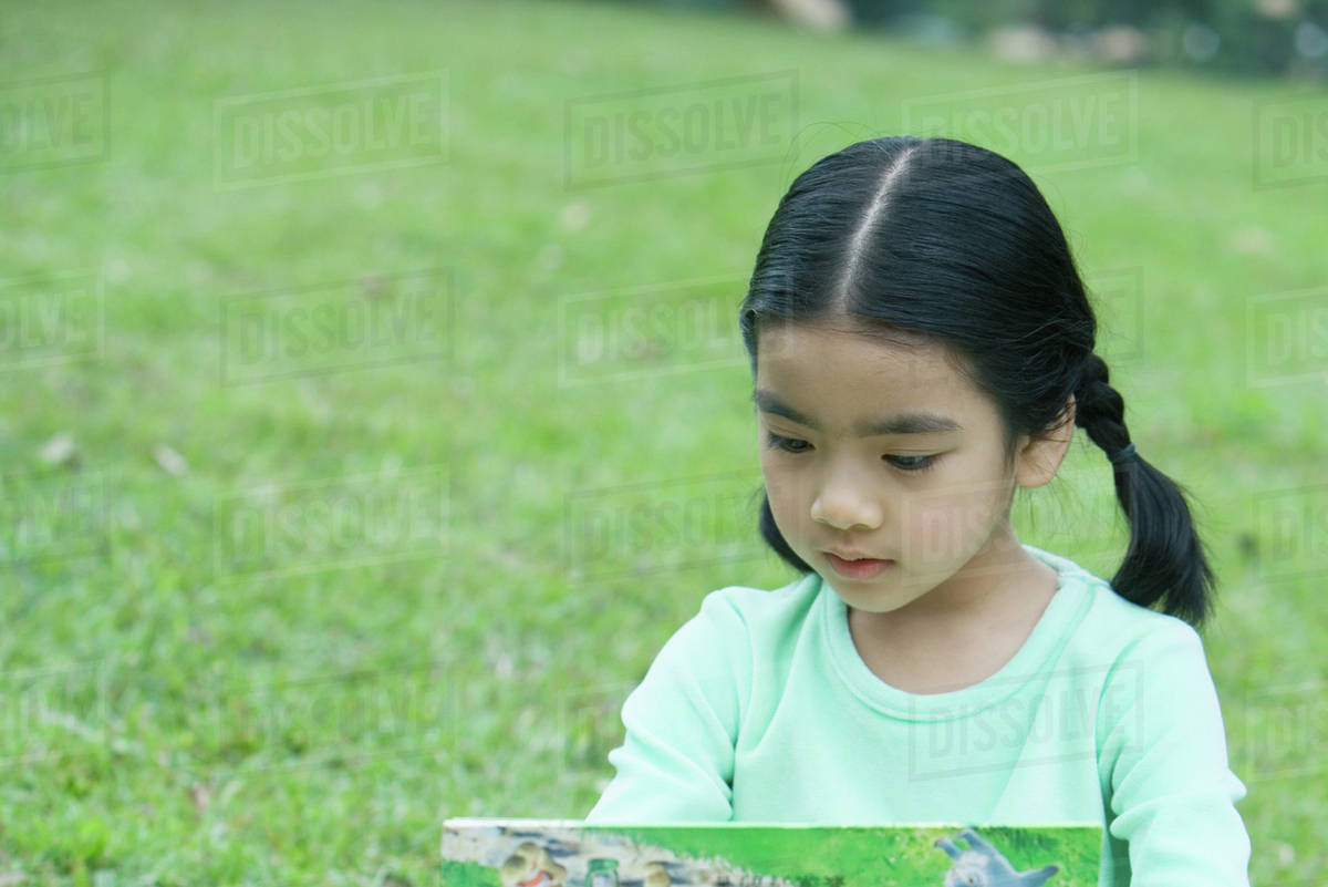 Little girl reading book - Stock Photo - Dissolve