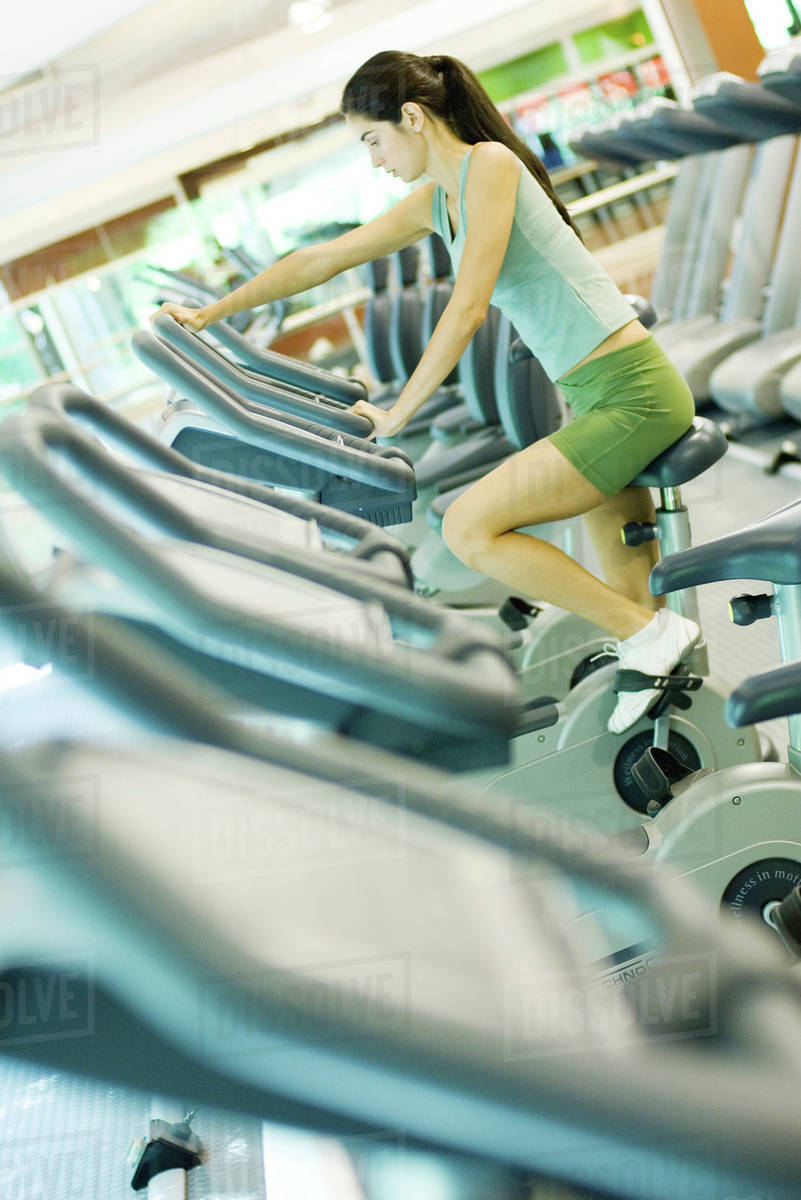 Woman riding exercise bike - Royalty-free Stock Photo | Dissolve