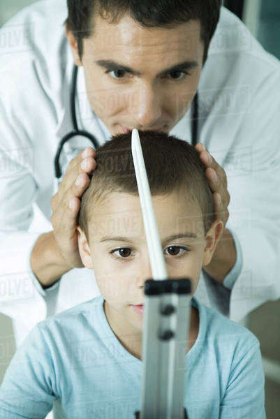Doctor measuring boy during check-up - Royalty-free Stock Photo | Dissolve