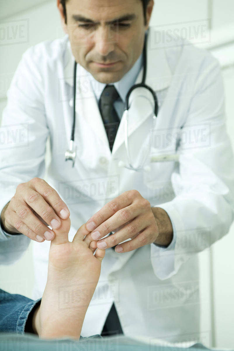 Doctor touching child's toes - Royalty-free Stock Photo | Dissolve