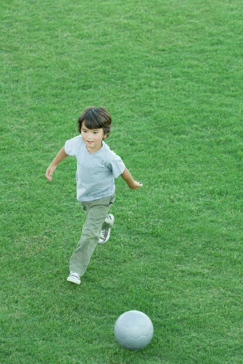 Boy playing soccer on grass, high angle view, full length - Stock Photo ...