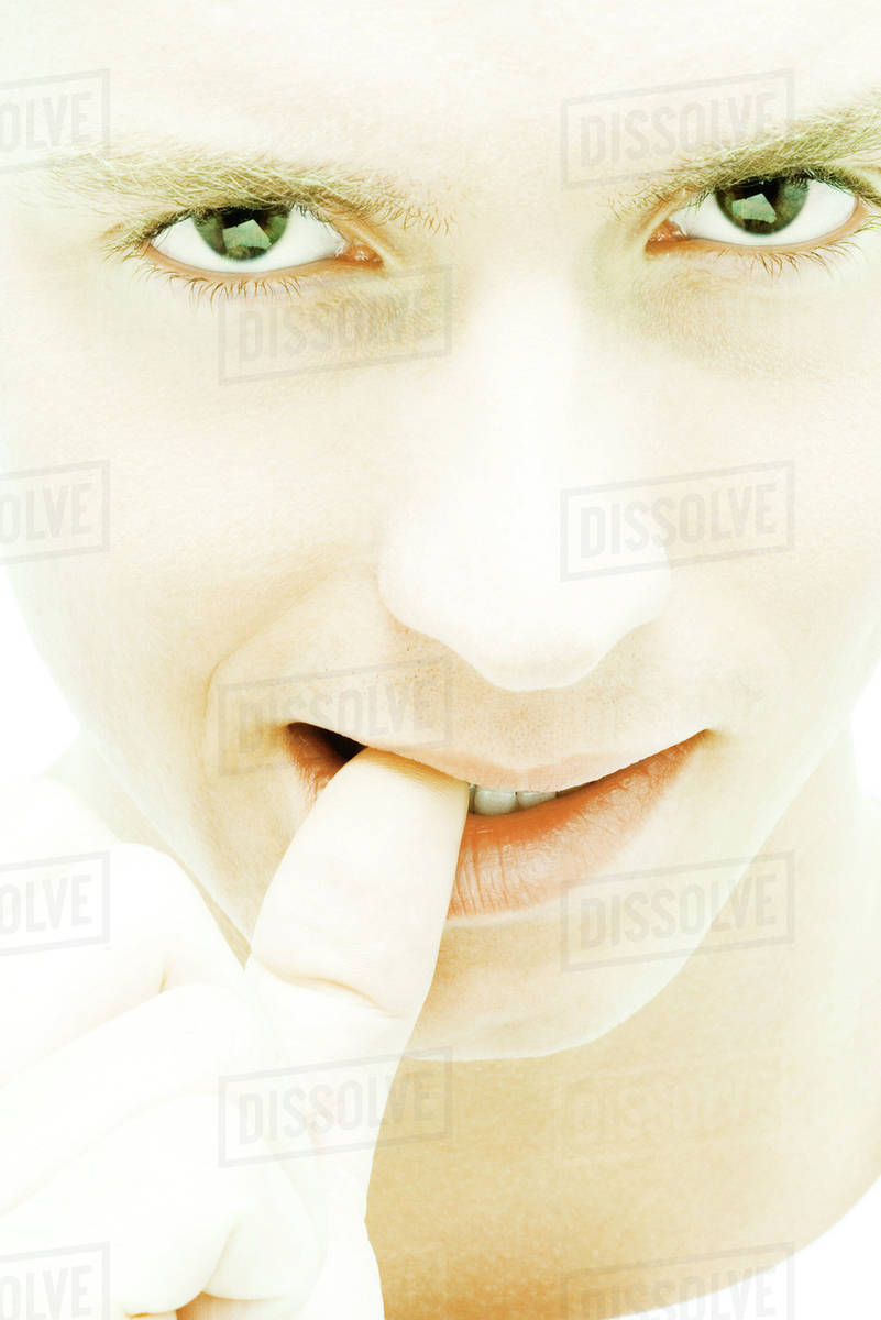 Young man biting thumb - Stock Photo - Dissolve