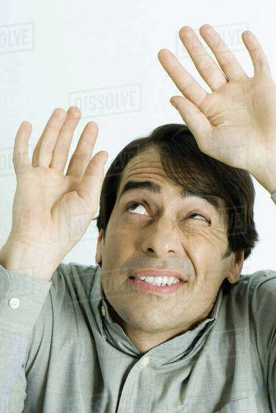 Man holding up hands protectively, looking up, portrait - Royalty-free ...