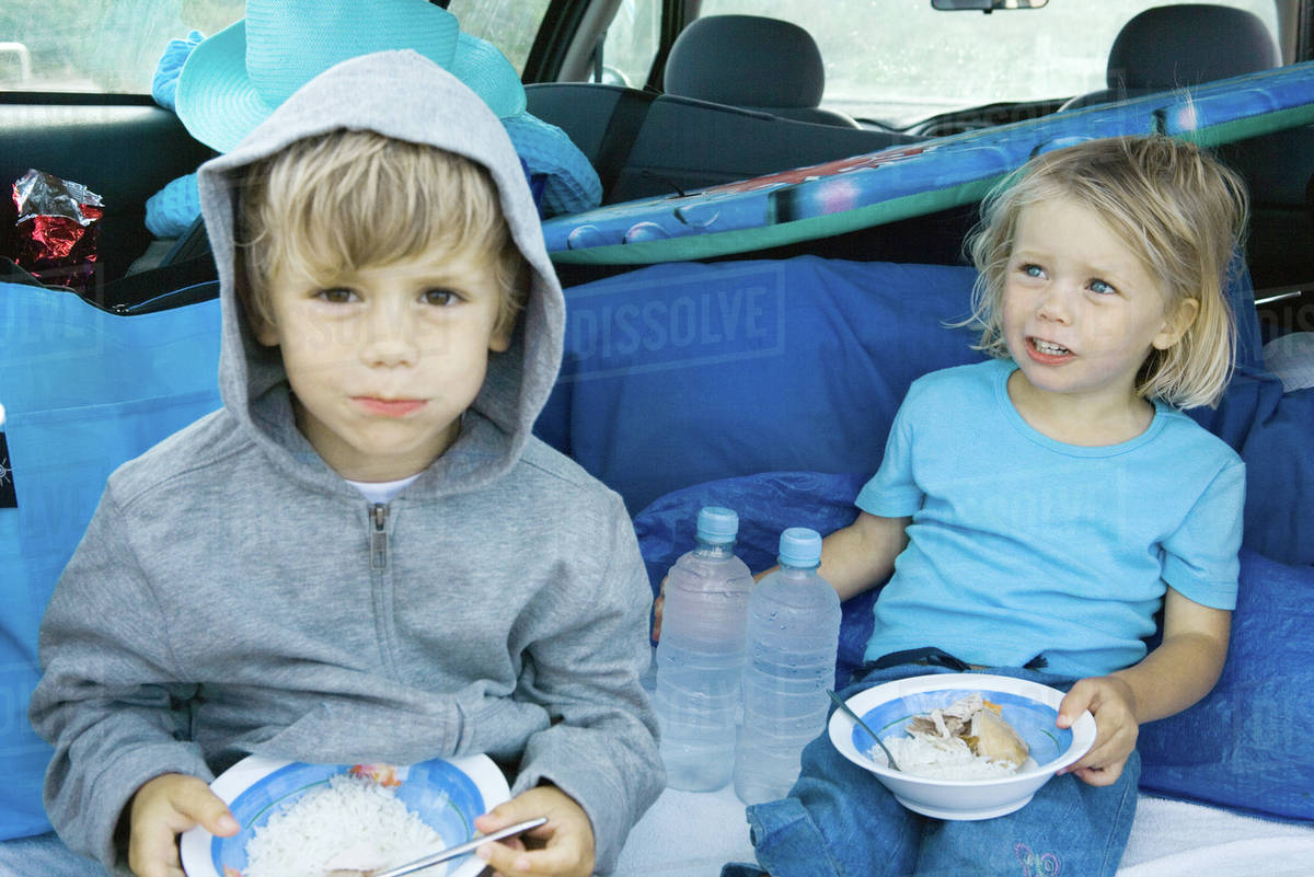 Children eating meal in back of car - Royalty-free Stock Photo | Dissolve