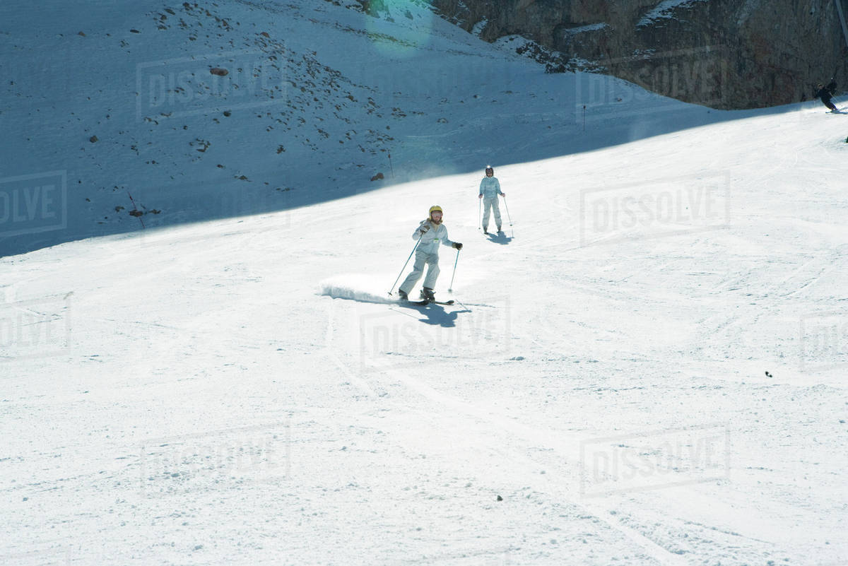 Young skiers on ski slope, full length, in the distance - Stock Photo ...