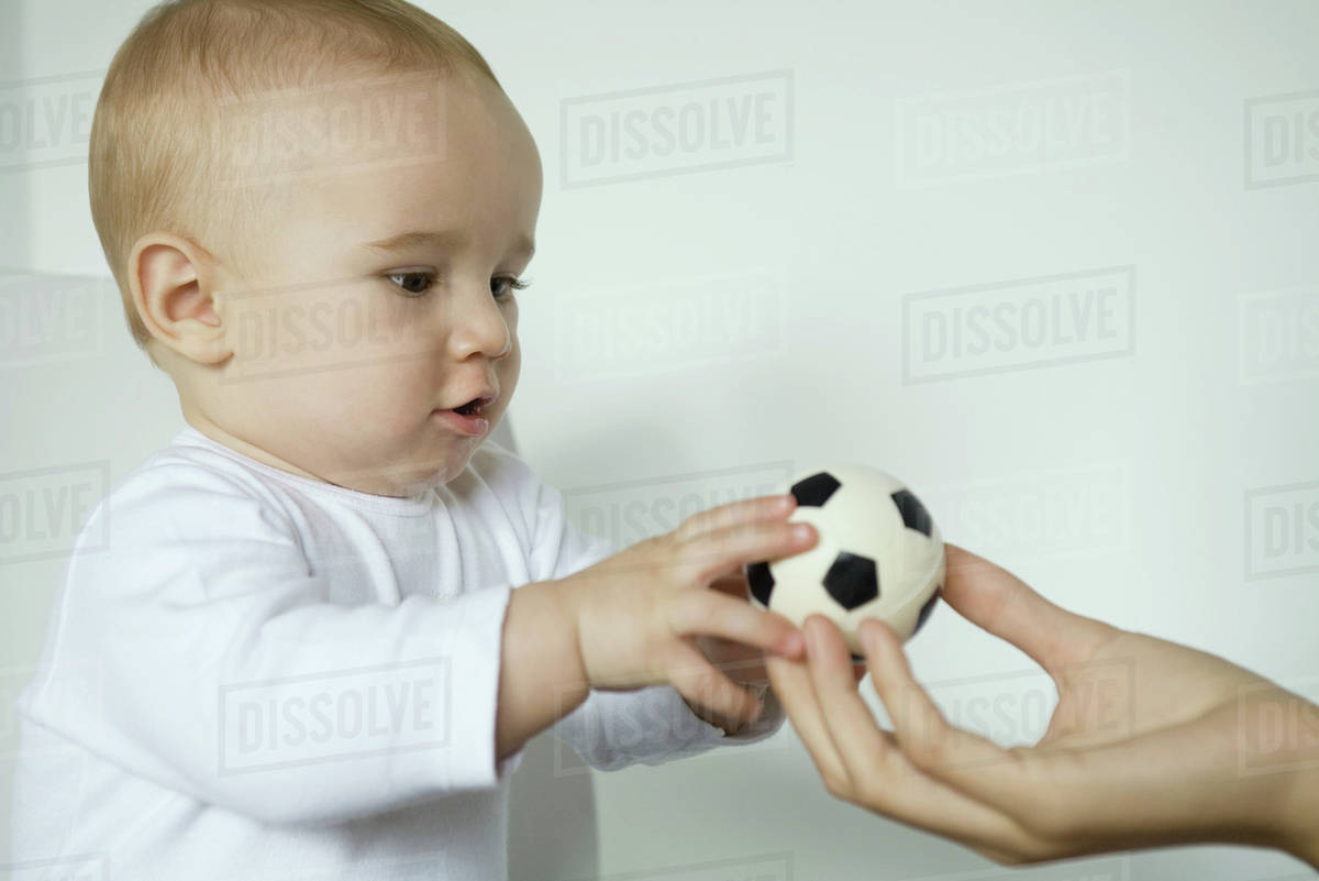 Baby taking ball from mother's hand, close-up - Royalty-free Stock ...