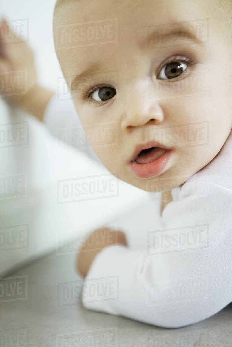 Baby turning head to look at camera, close-up - Stock Photo - Dissolve