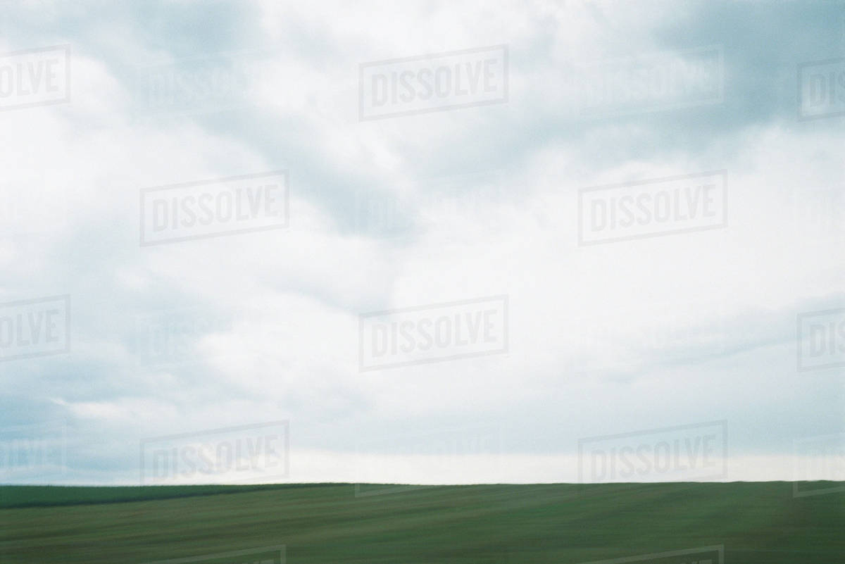 Green field and cloudy sky - Royalty-free Stock Photo | Dissolve