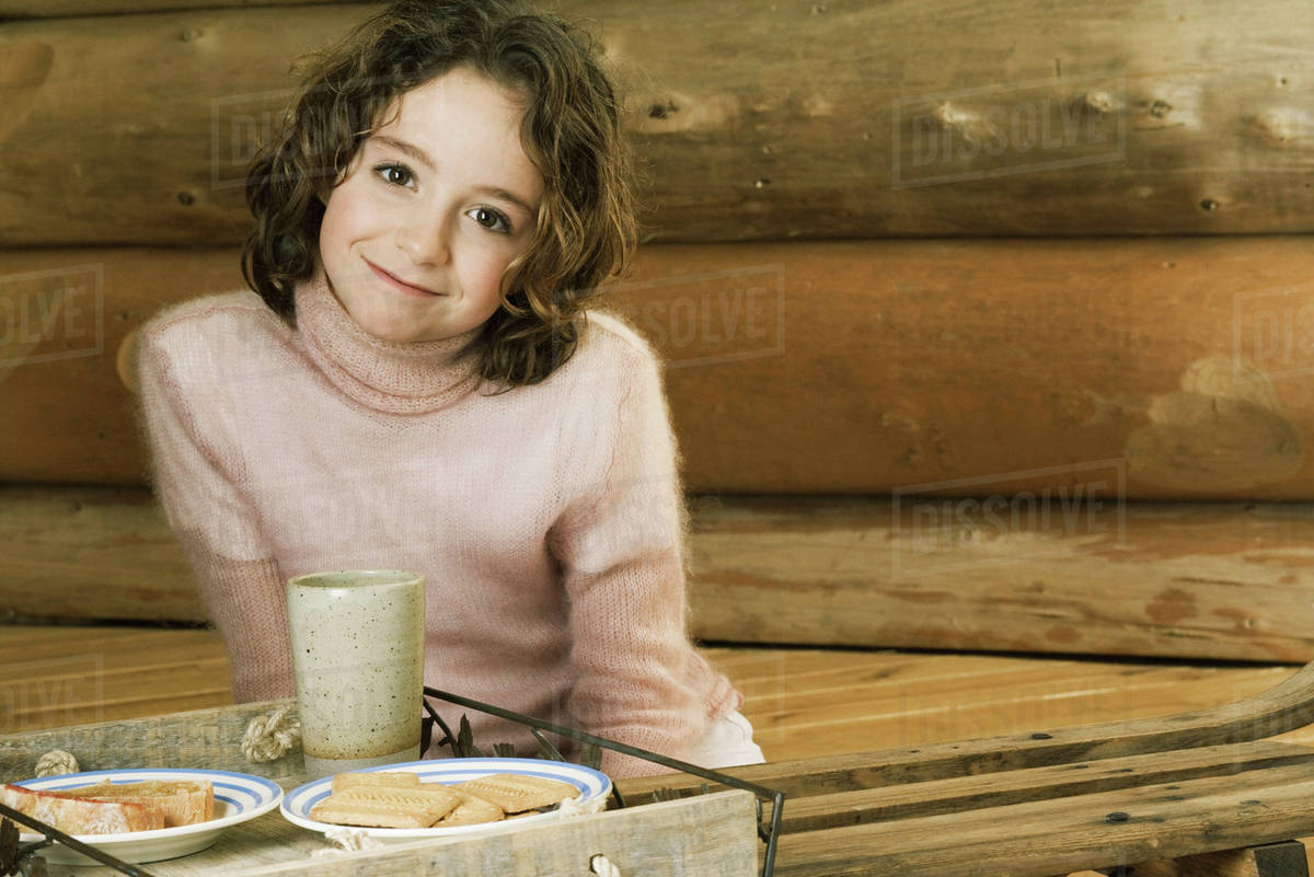 Girl having snack, smiling at camera - Stock Photo - Dissolve