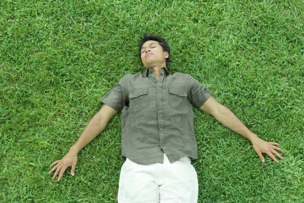 Man lying on back in grass, eyes closed - Royalty-free Stock Photo ...