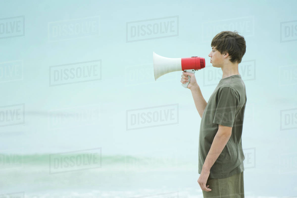 Boy using megaphone, side view - Royalty-free Stock Photo | Dissolve