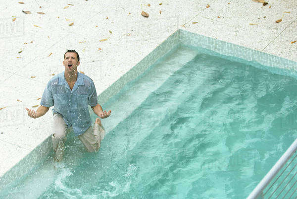 Man splashing in pool, fully clothed, shouting and gesticulating, high ...