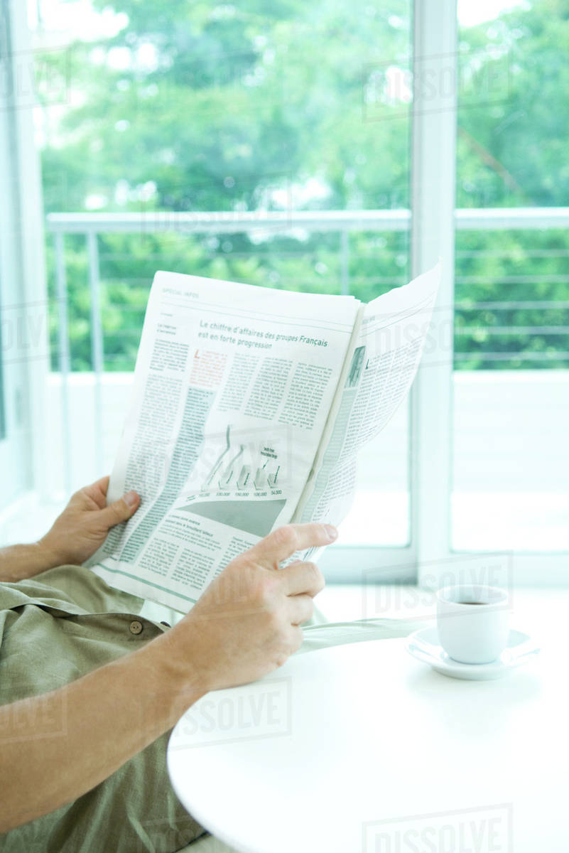 Man reading newspaper at table, cropped view - Royalty-free Stock Photo ...