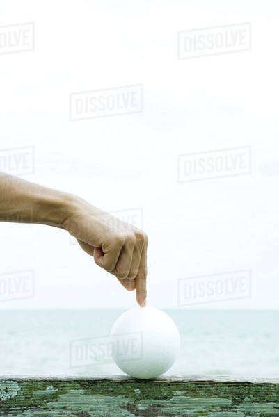 Man touching ball with index finger, cropped view of hand - Royalty ...