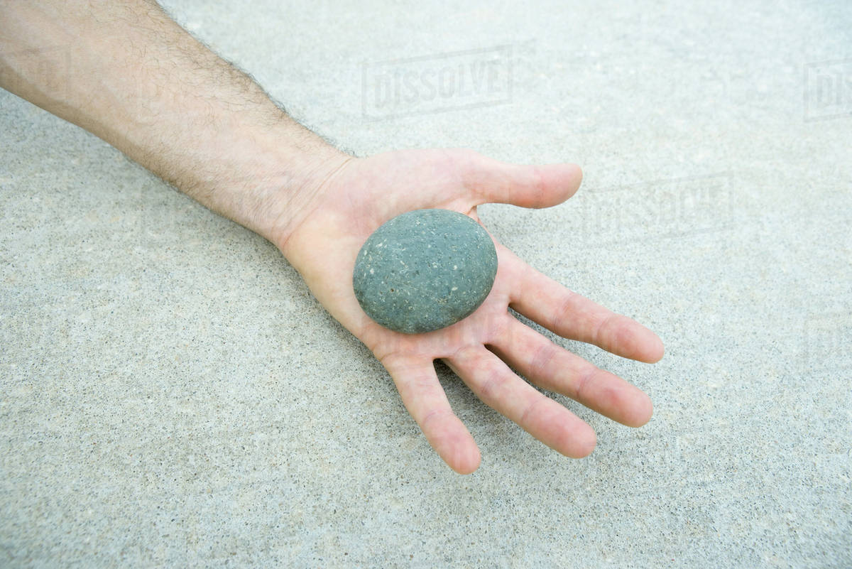 Man holding pebble in hand, cropped view - Royalty-free Stock Photo ...