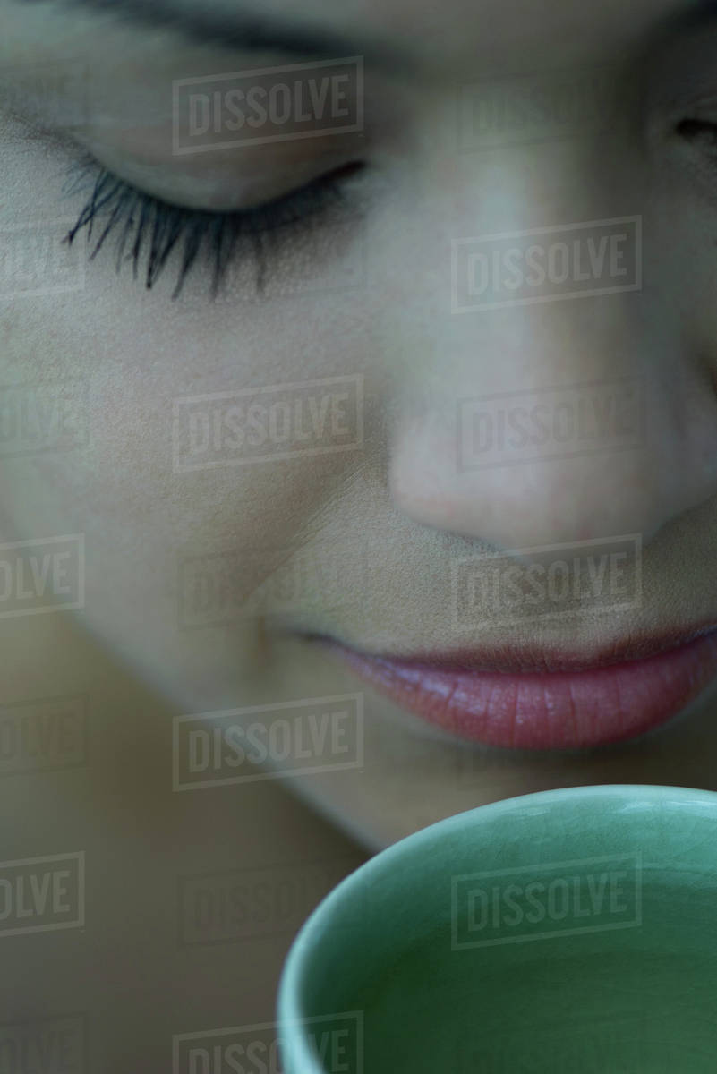 Woman smelling cup of tea with eyes closed, close-up - Royalty-free ...