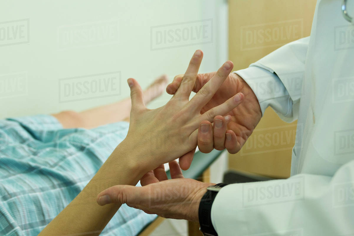 Doctor examining patient's hand - Royalty-free Stock Photo | Dissolve