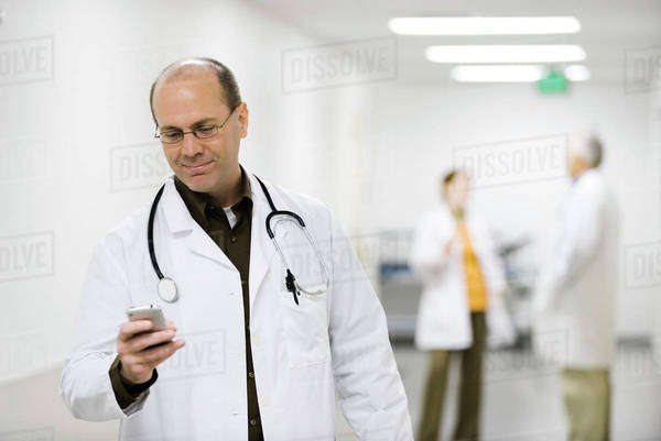 Doctor using cell phone - Stock Photo - Dissolve