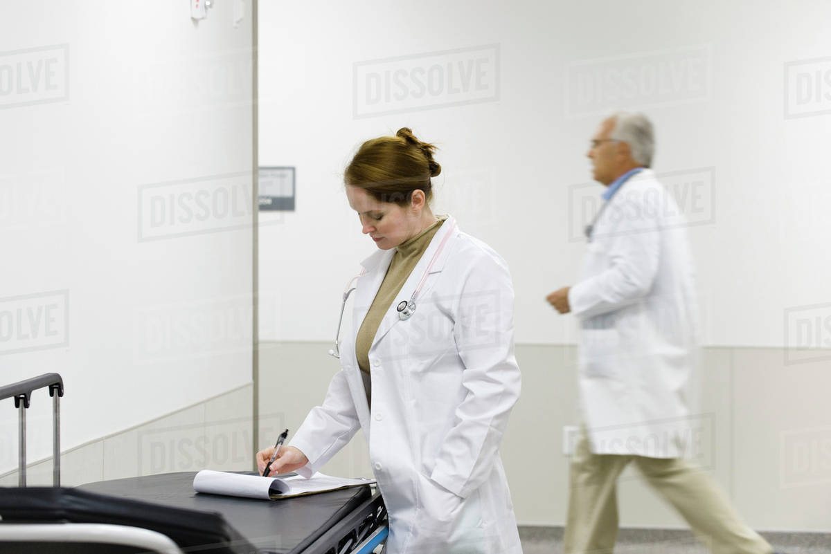 Female doctor looking at medical chart - Royalty-free Stock Photo ...
