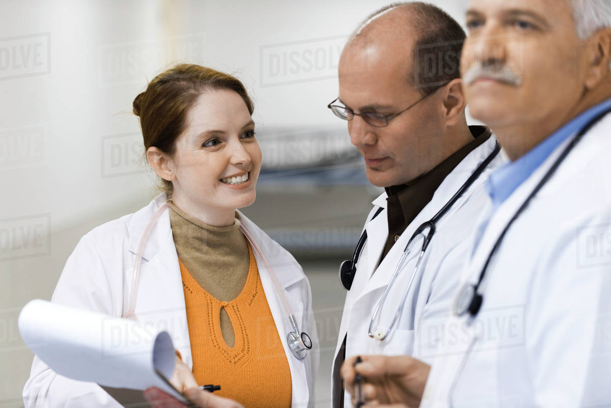 Doctor showing colleague medical chart - Stock Photo - Dissolve