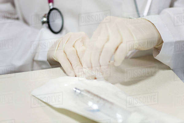 Healthcare worker opening sterile package containing medical supplies ...