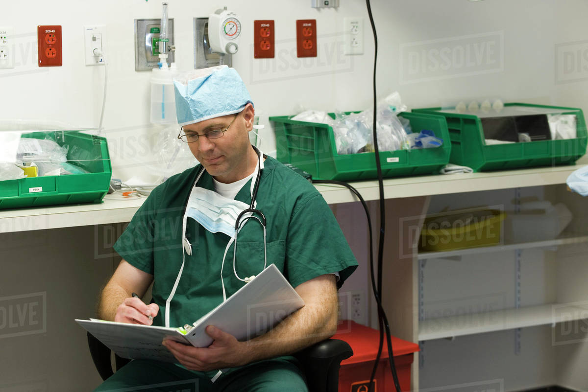 Surgeon completing paperwork - Stock Photo - Dissolve